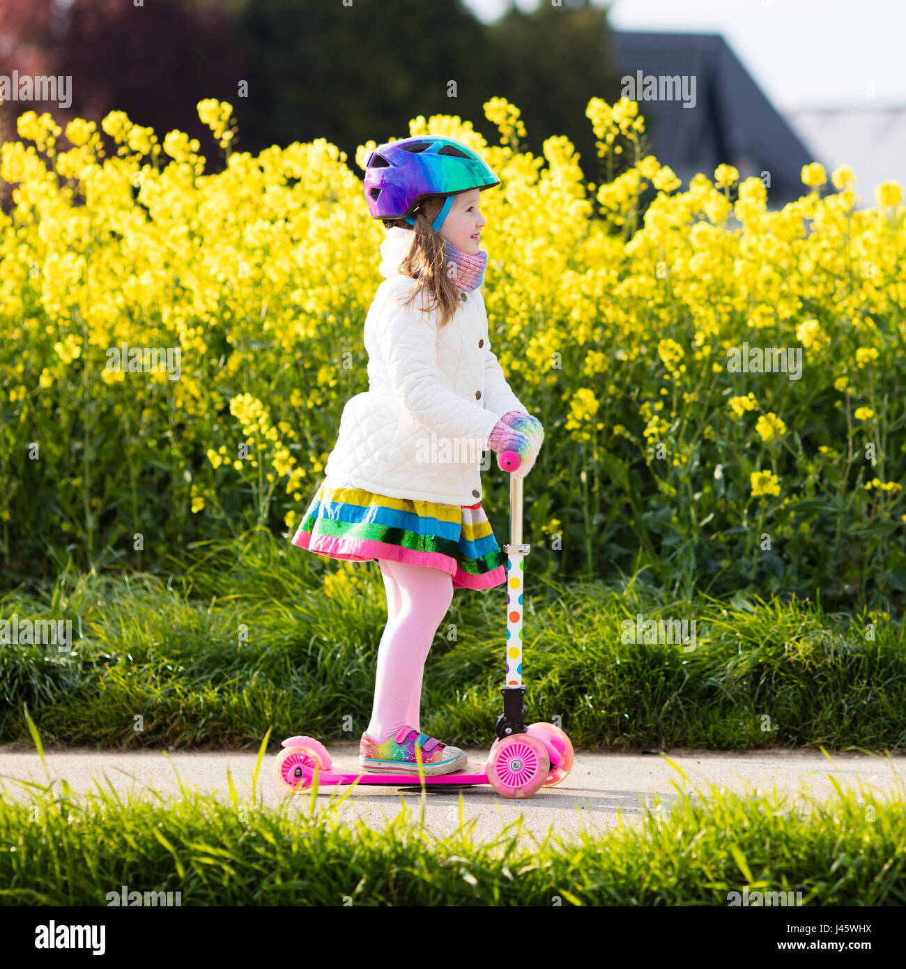 Child riding scooter on way back to school. Little girl playing ...