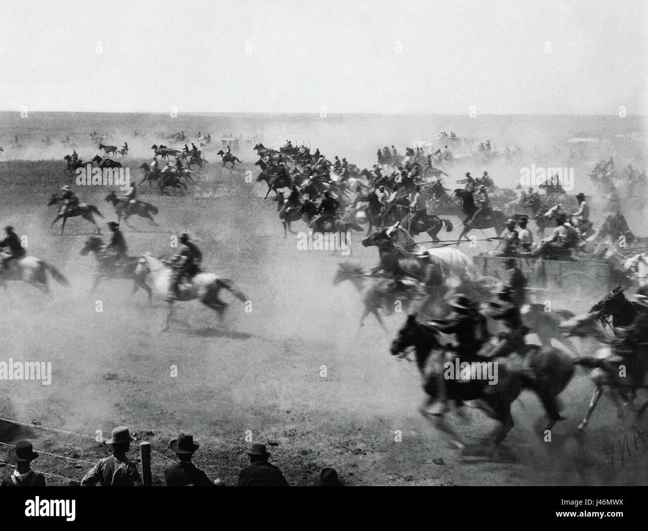The image captures a moment from the Oklahoma Land Rush, focusing on ...
