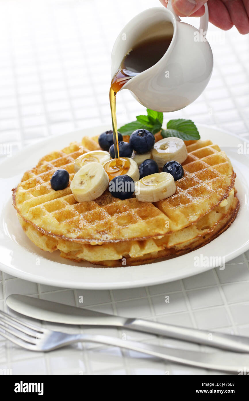 pouring maple syrup over homemade american round waffles Stock Photo ...