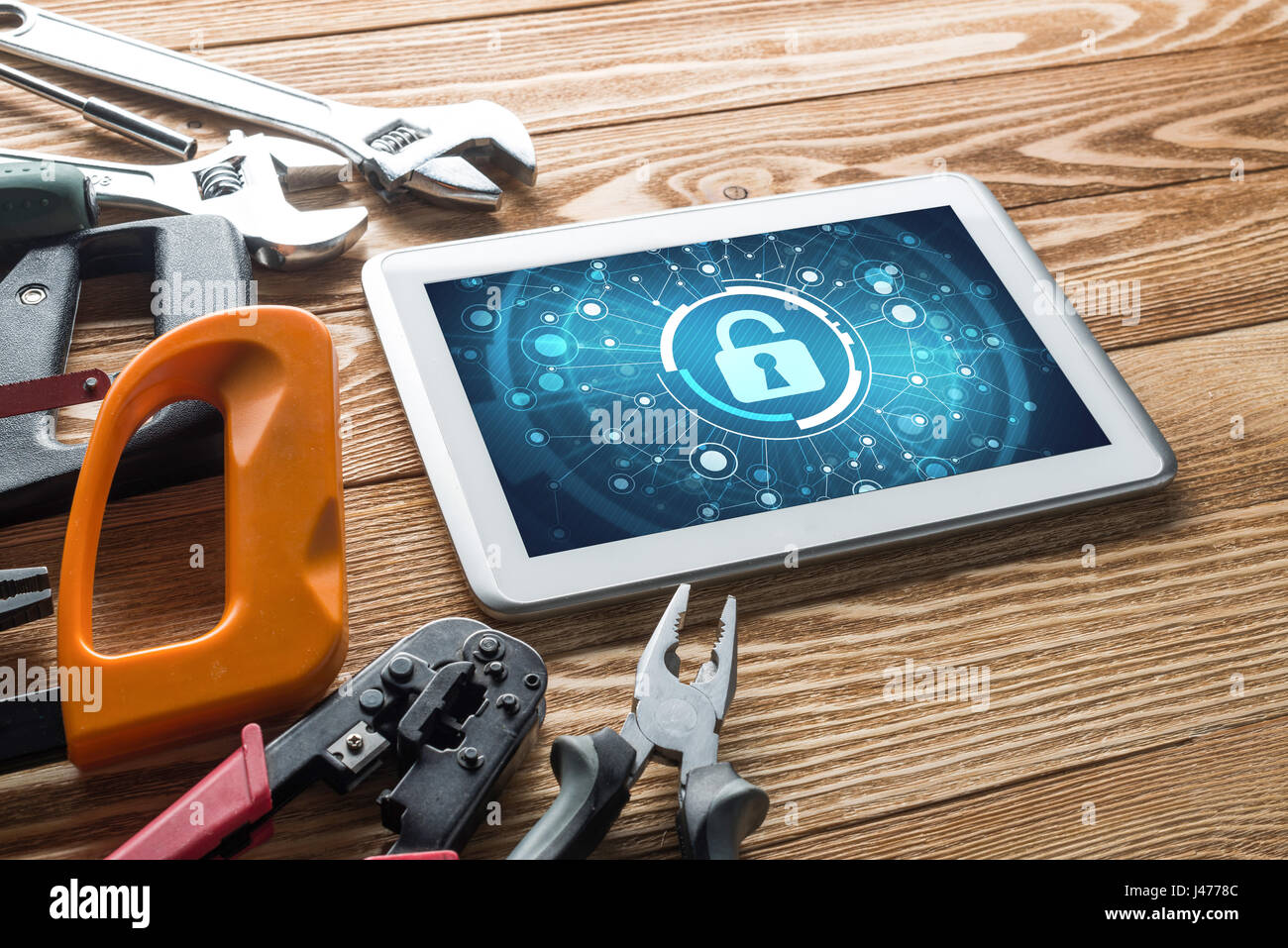 Tablet pc with security concept on screen and industrial tools around ...