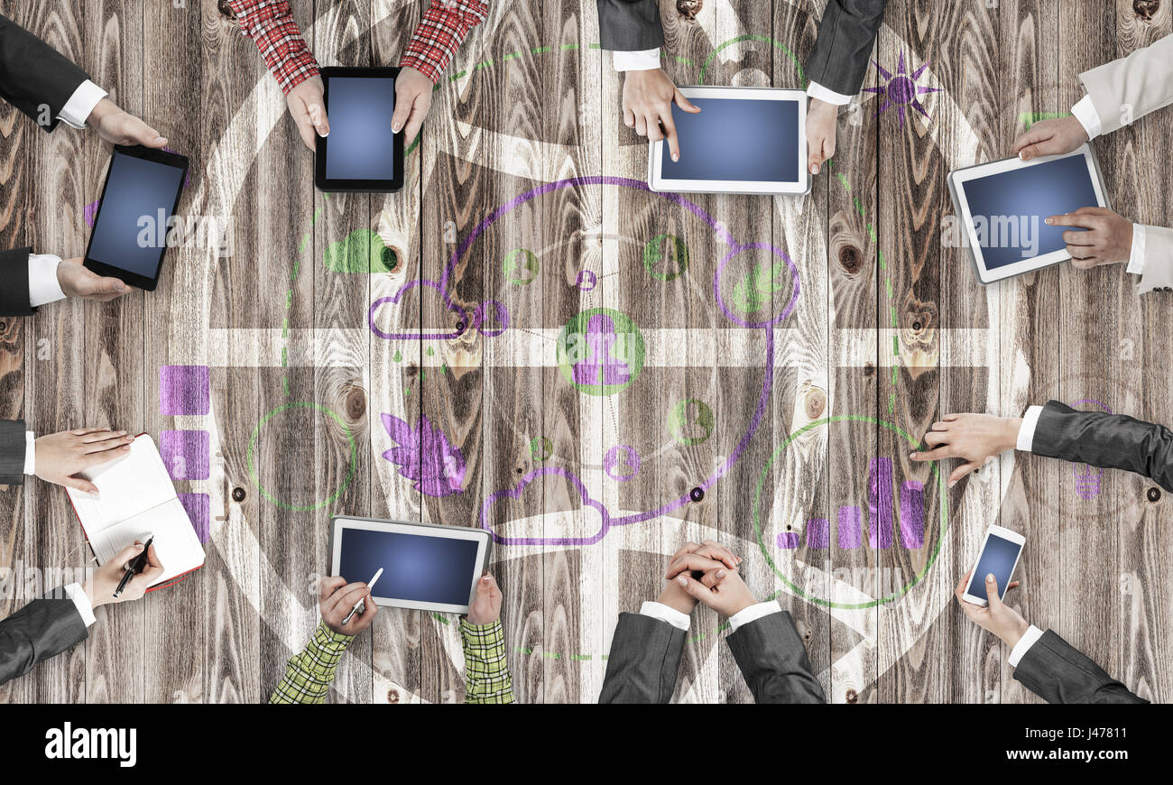 Group of people with devices in hands working together as symbol of ...