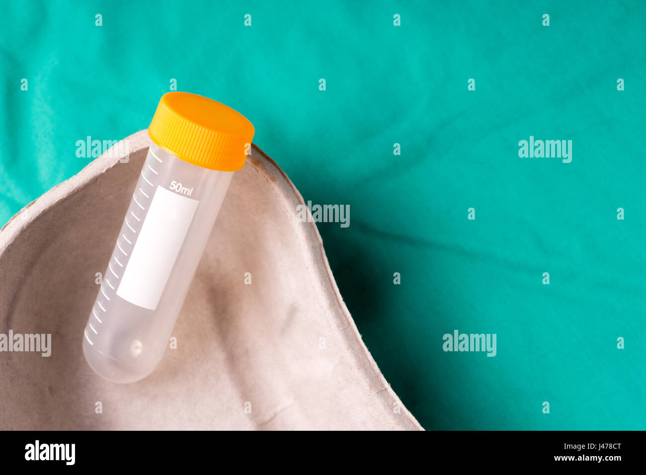 Medical test tube lying in a one use capsule on the hospital's green ...