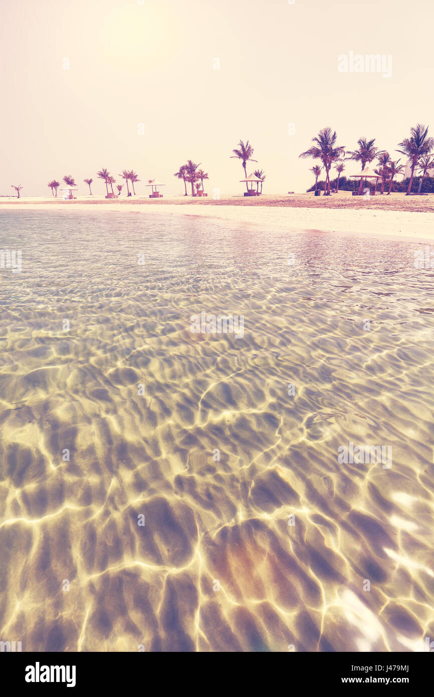 Retro stylized photo of a beautiful beach with crystal clear water ...