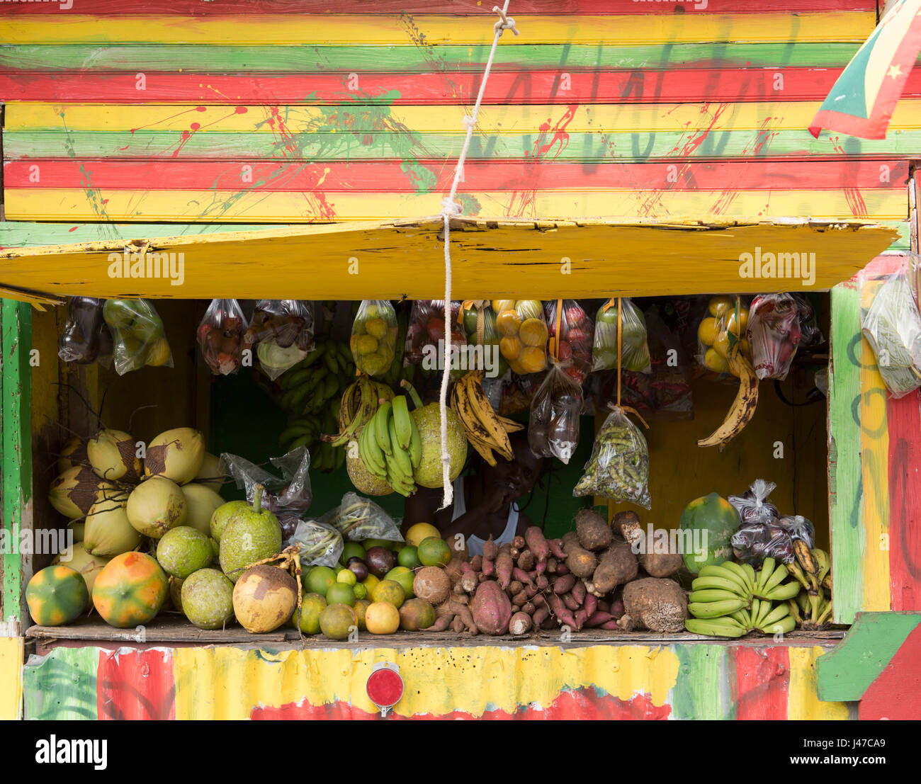 A colourfully painted roadside stand selling a large variety of fruit ...
