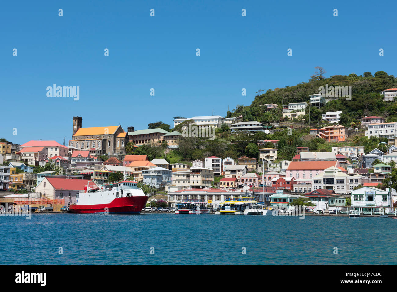 Boats in the Carenage surrounded by colourful buildings on a hill in St ...
