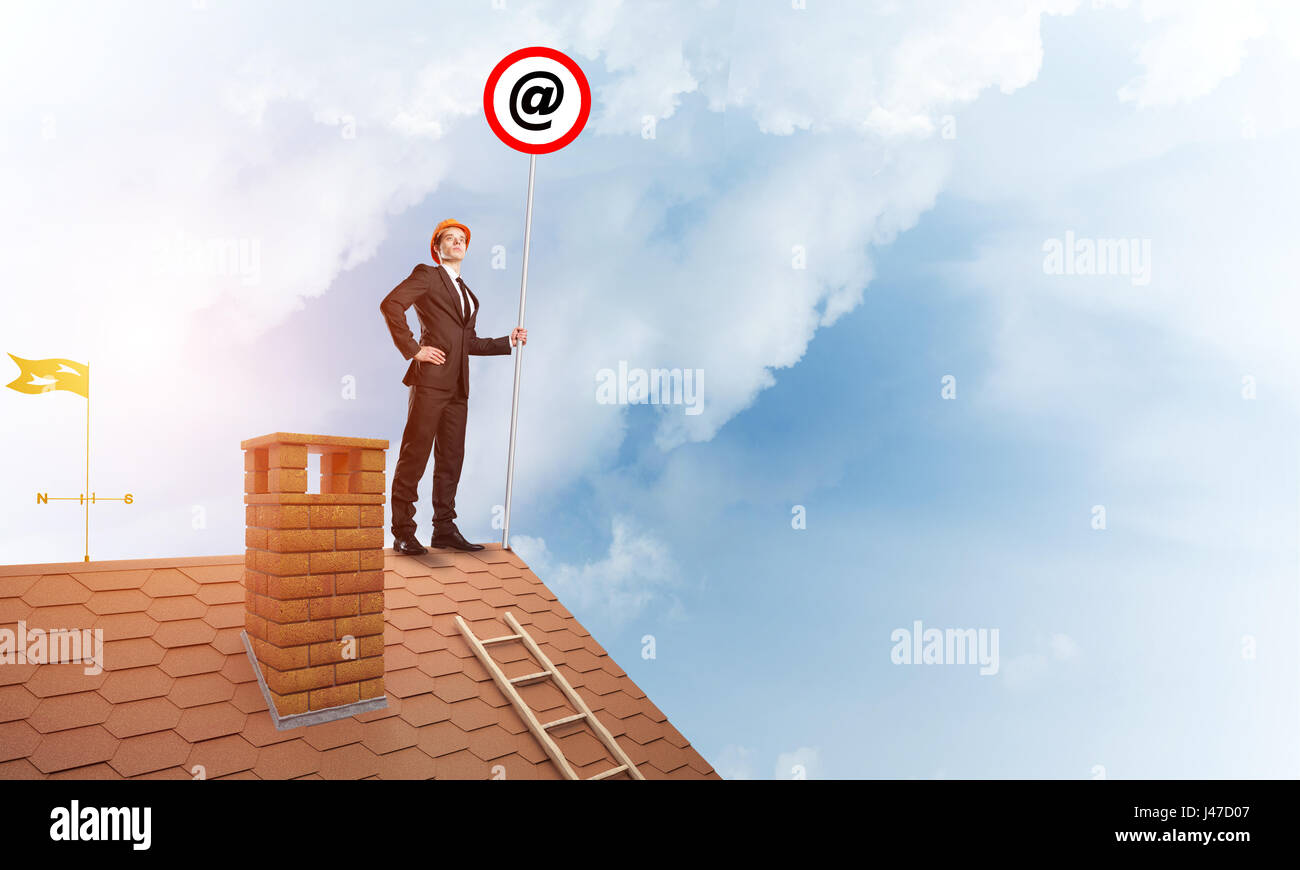 Businessman in suit and helmet presenting email concept on signbaord ...