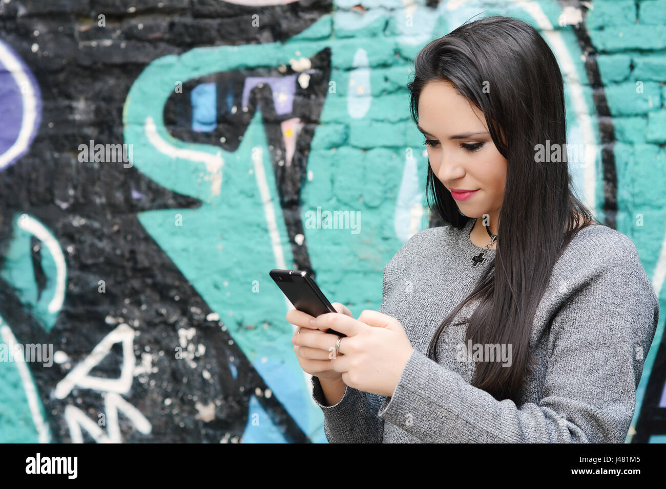 Portrait of a young beautiful woman sending messages with her ...