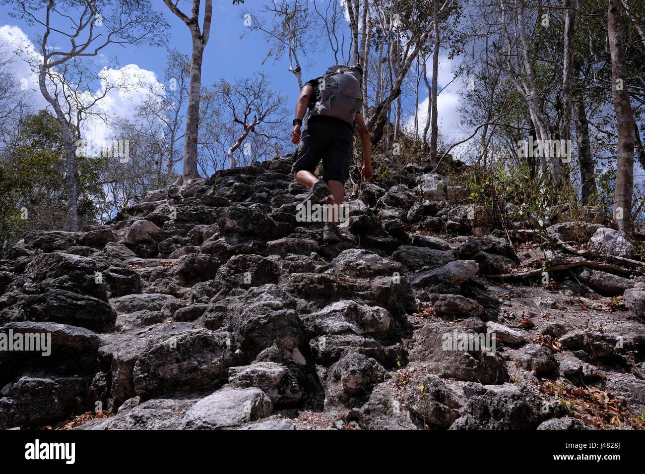 A hiker climbing a small pyramid structure on the side of the main ...