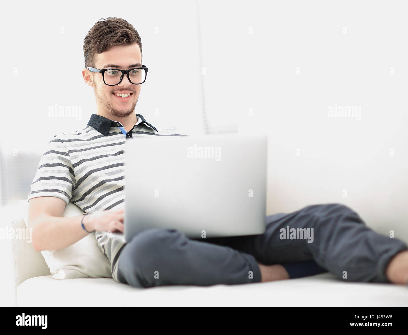 Man Relaxing on Sofa with Laptop Computer Stock Photo - Alamy