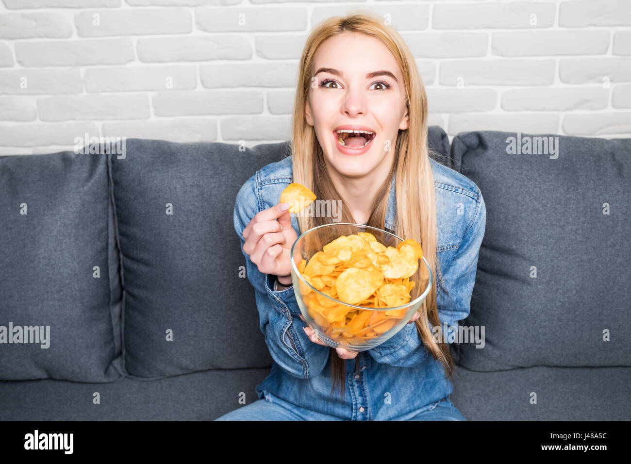 Portrait of smiling girl eating chips at home Stock Photo - Alamy