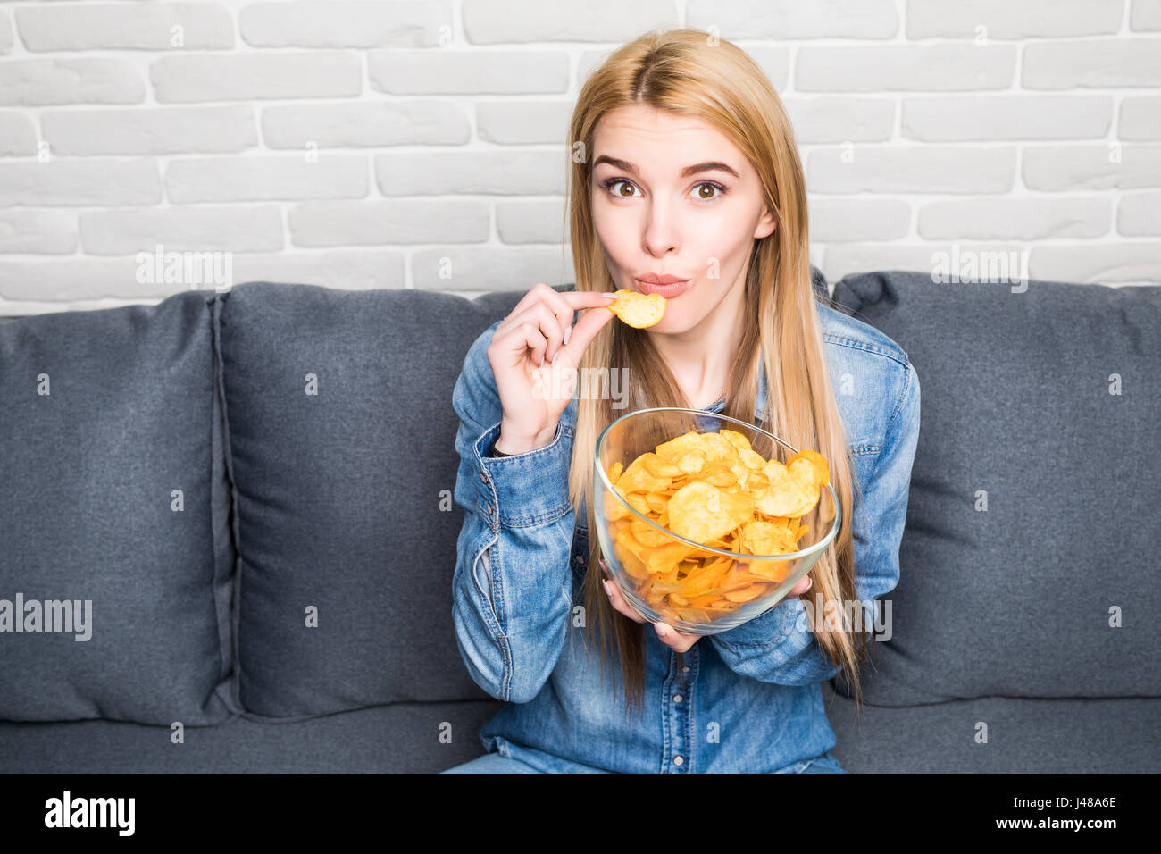 Portrait of smiling girl eating chips at home Stock Photo - Alamy