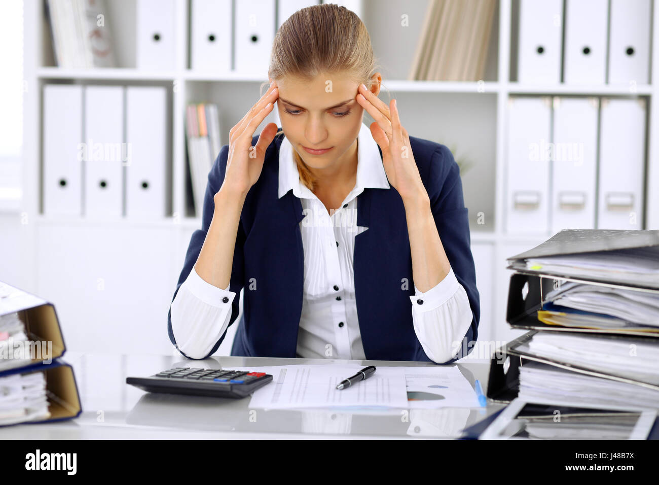 Tired business woman or female accountant with bills and paper folders ...