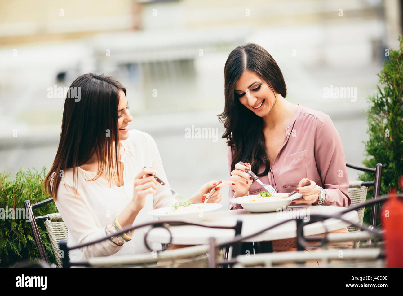 Pretty young women having lunch in the restaurant outdoor Stock Photo ...