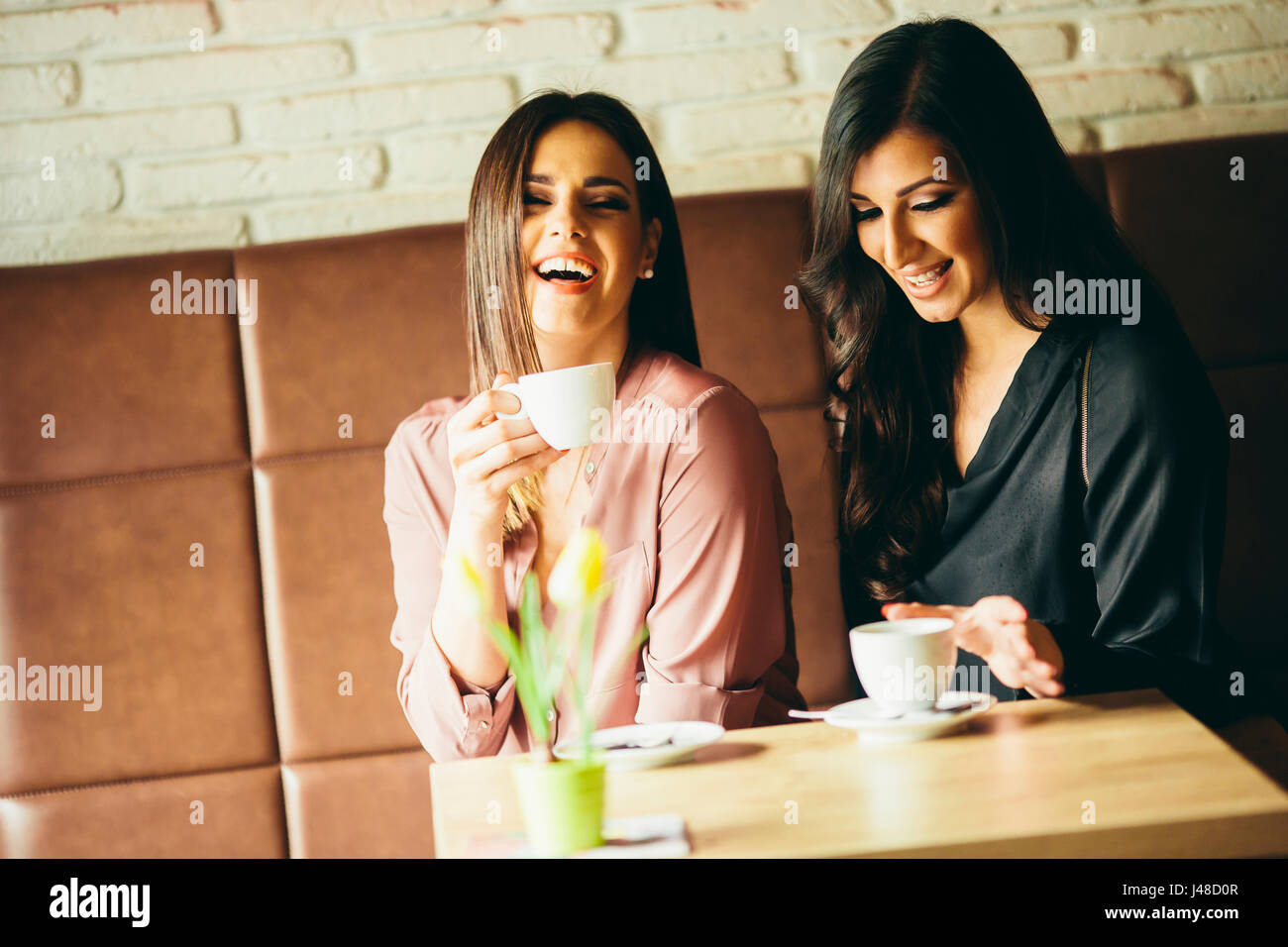 Two friends relaxing and drinking coffee Stock Photo - Alamy