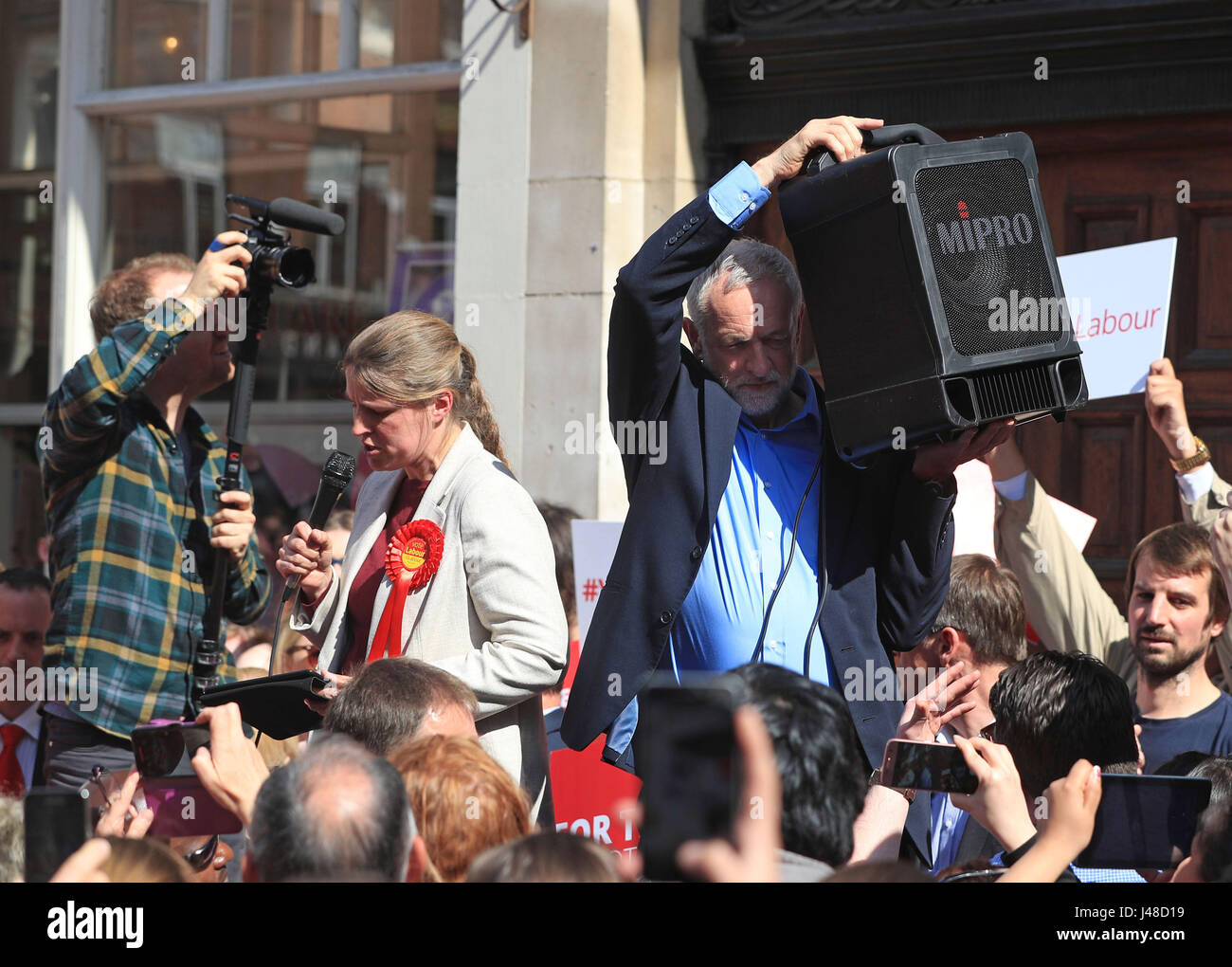 Labour leader Jeremy Corbyn holds up a speaker so the crowd can hear a ...