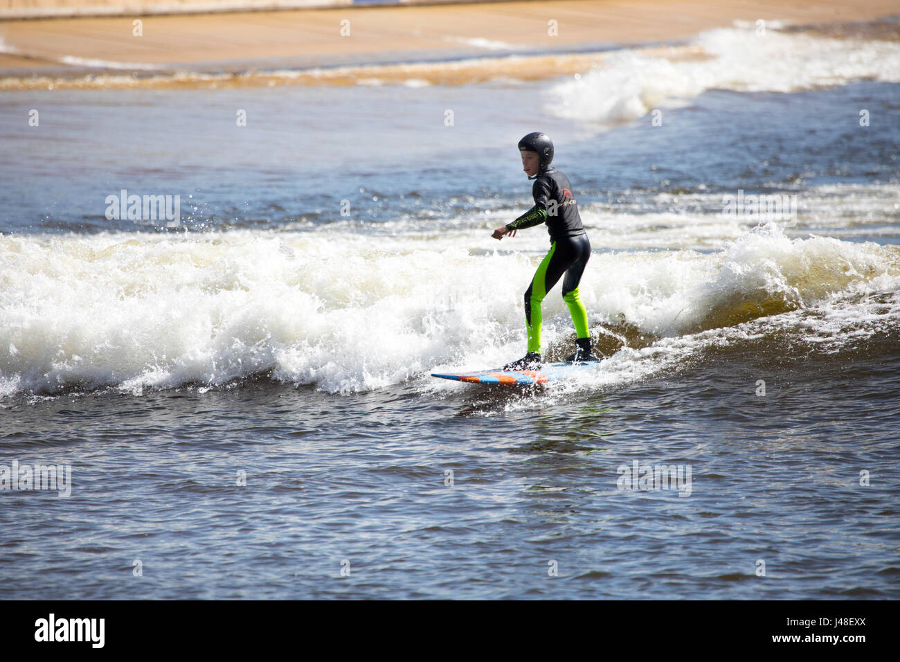 A surfer riding a wave at the artificial wave pool in the Conwy Valley ...
