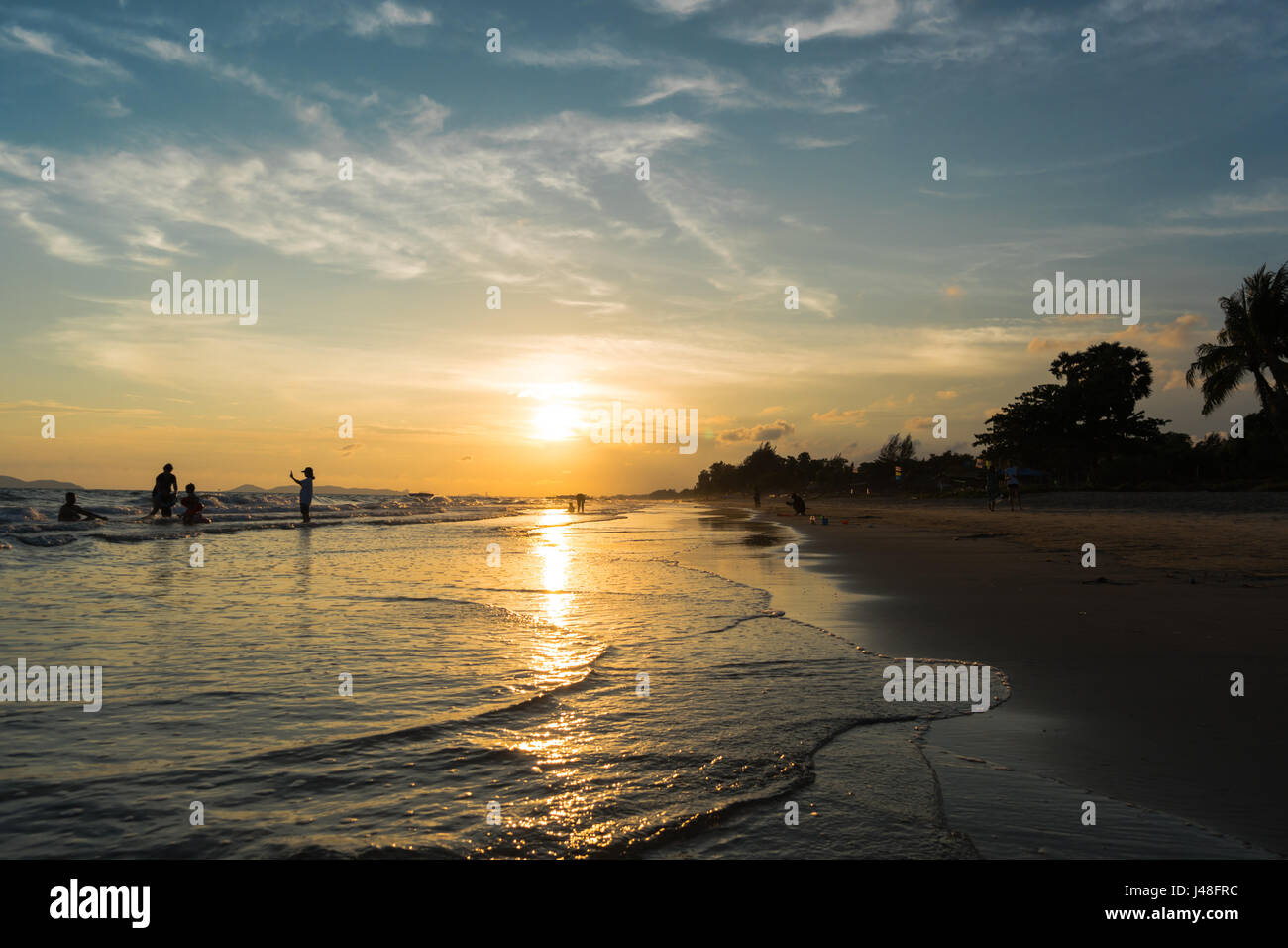 Sunset light shimmering water surface on tropical beach Stock Photo - Alamy