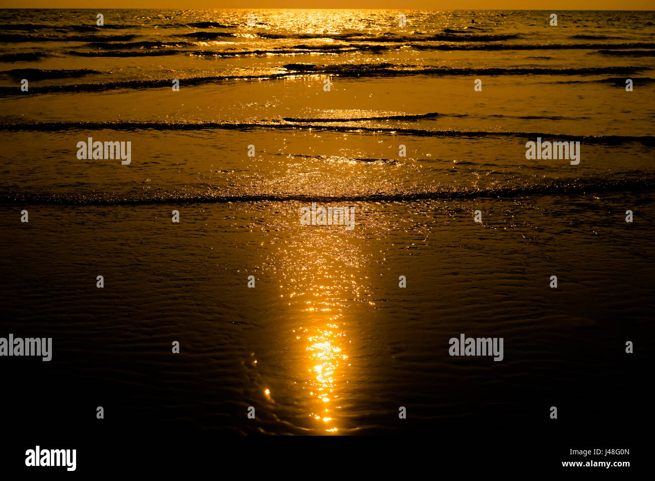 Sunset light shimmering water surface on tropical beach Stock Photo - Alamy