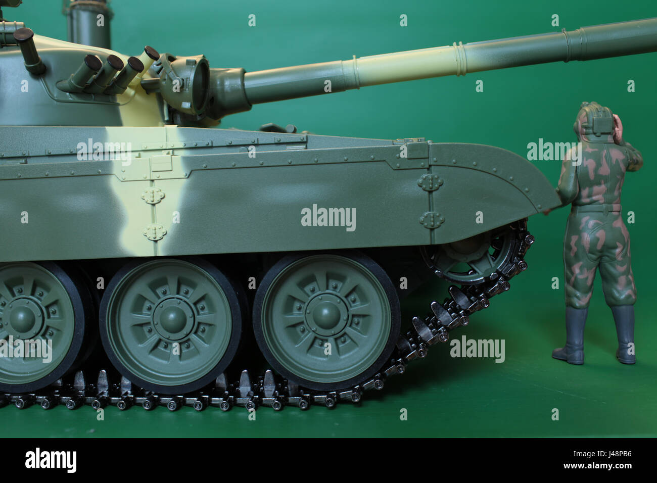 figure soldier in overalls and a helmet standing at battle tank Stock ...