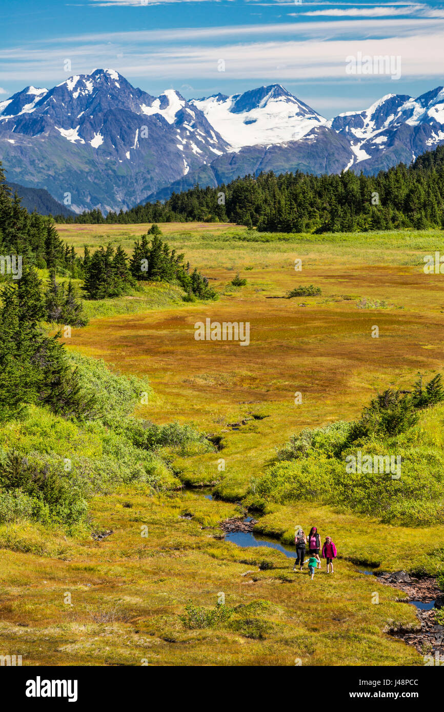 A small group of women hiking along a stream in Turnagain Pass, with ...
