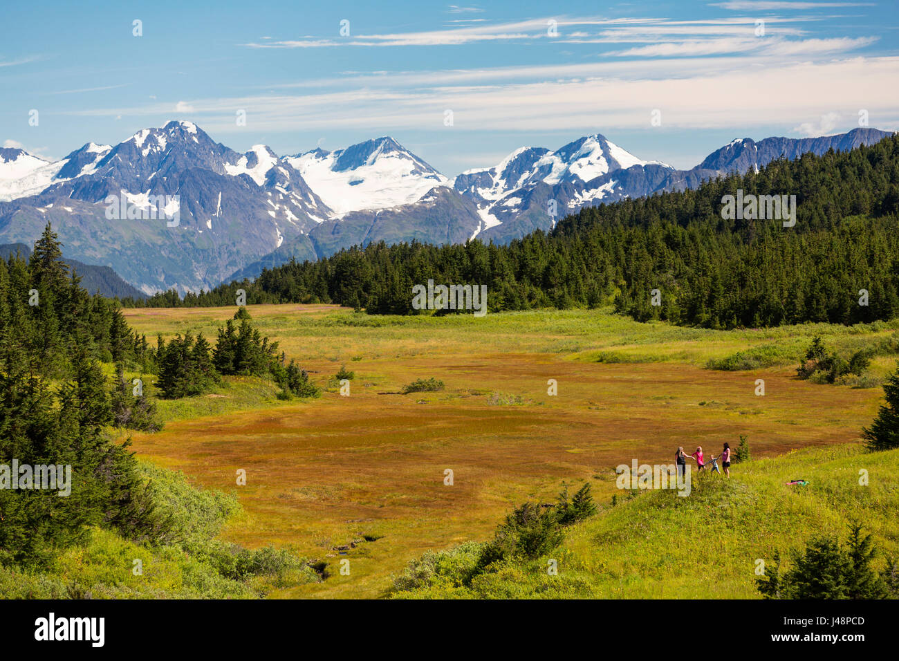 A small group of women hiking along a stream in Turnagain Pass, with ...