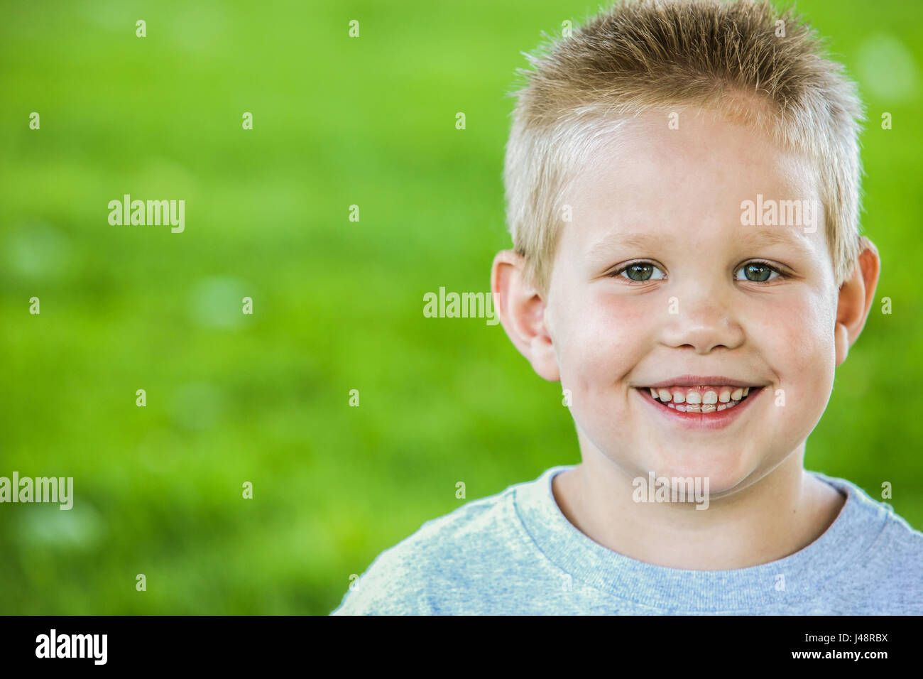 Portrait of a young boy with a grass field in the background; Oregon ...