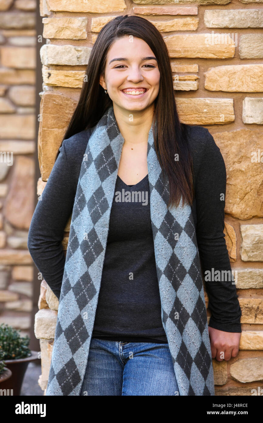 Portrait of a teenage girl standing against a stone wall; Oregon ...