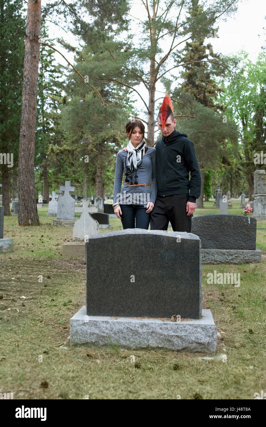 A Young Man And Young Woman Supporting Each Other In A Cemetery ...