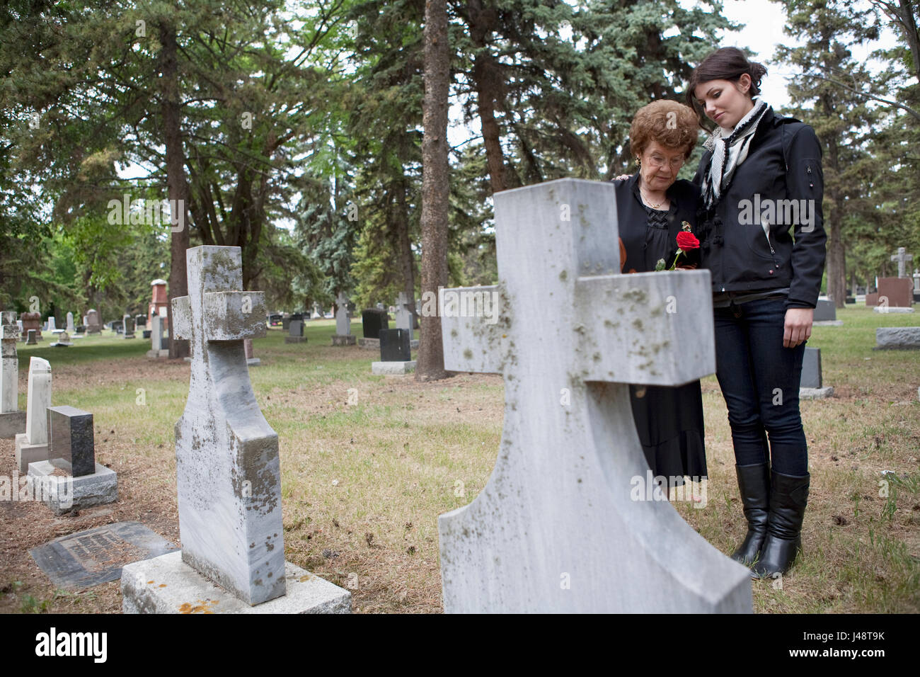 A Grandmother And Granddaughter Visiting A Grave In A Cemetery ...