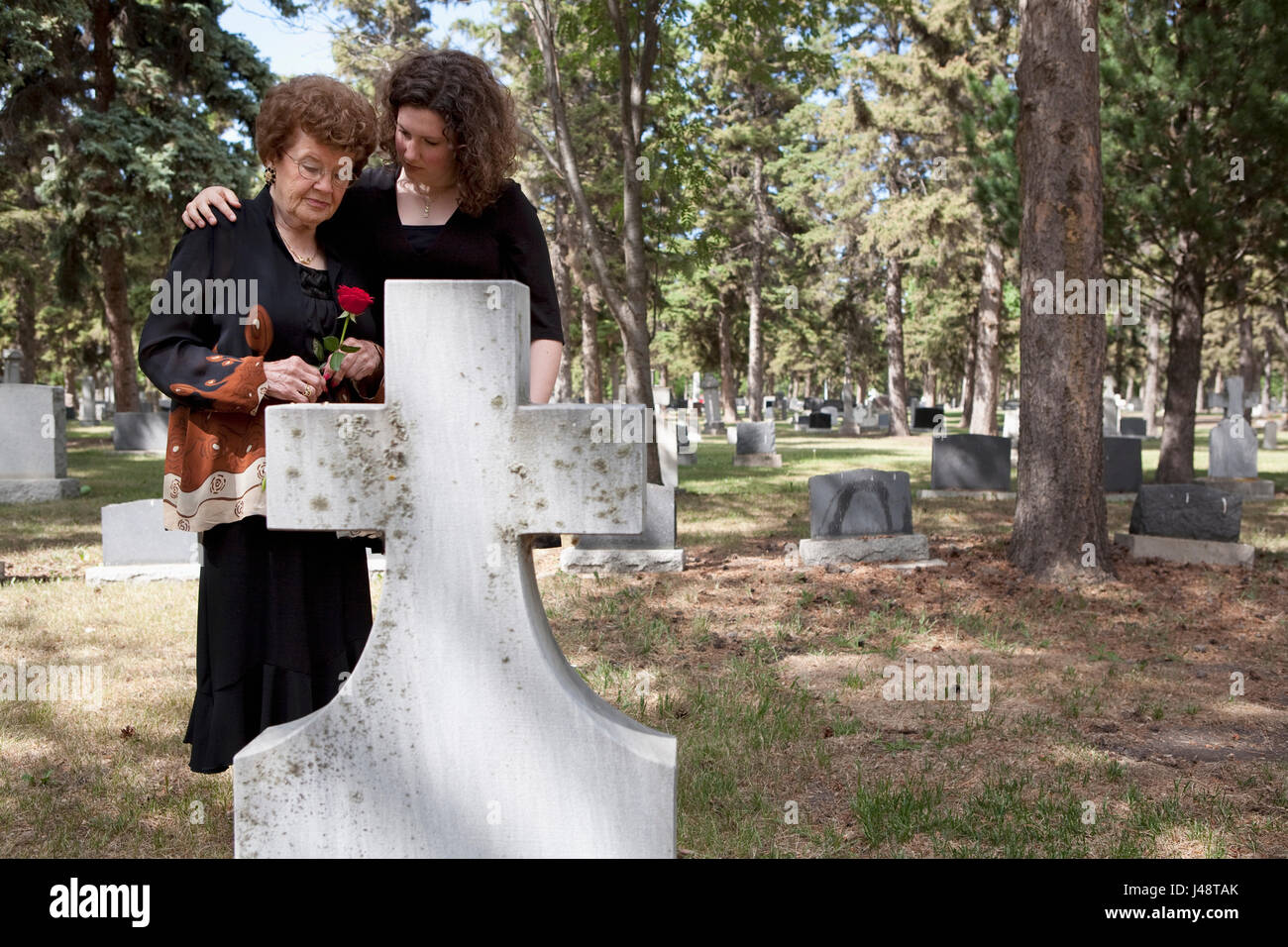 A Grandmother And Granddaughter Visiting A Grave In A Cemetery ...