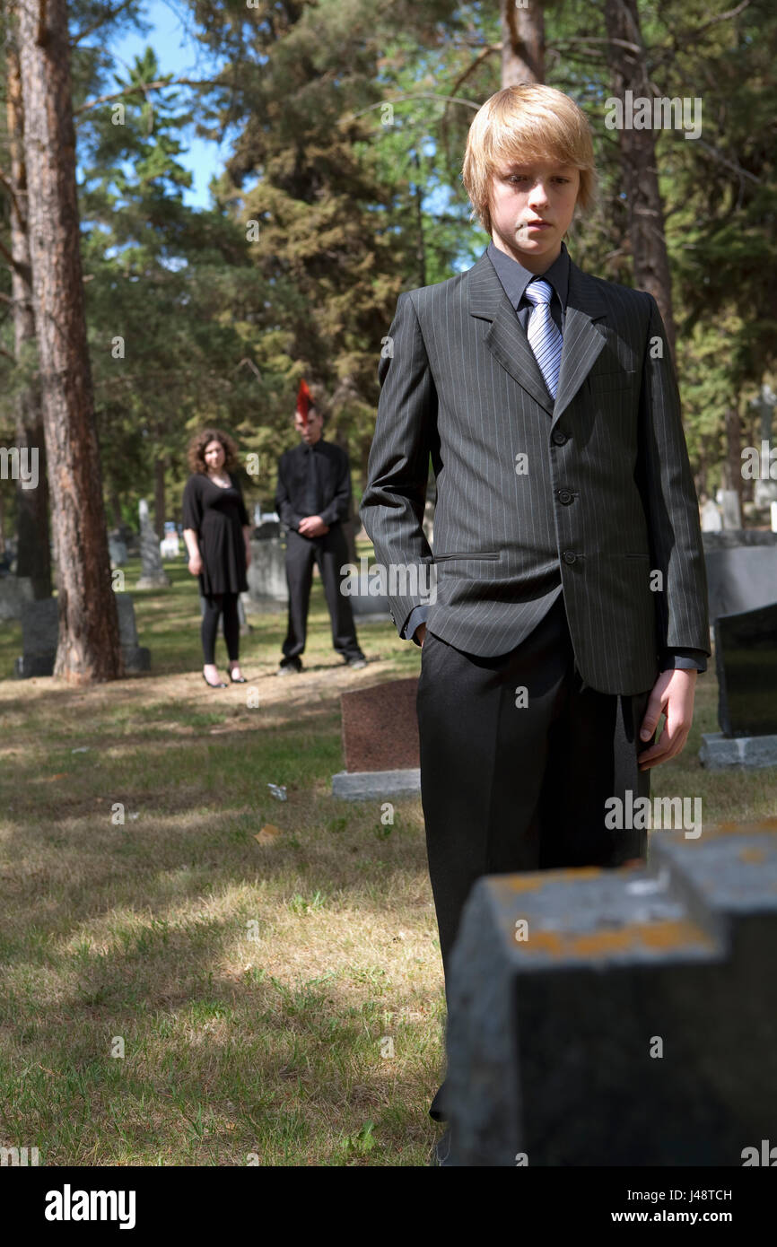 A Teenage Boy Visiting A Tombstone In A Cemetery; Edmonton, Alberta ...