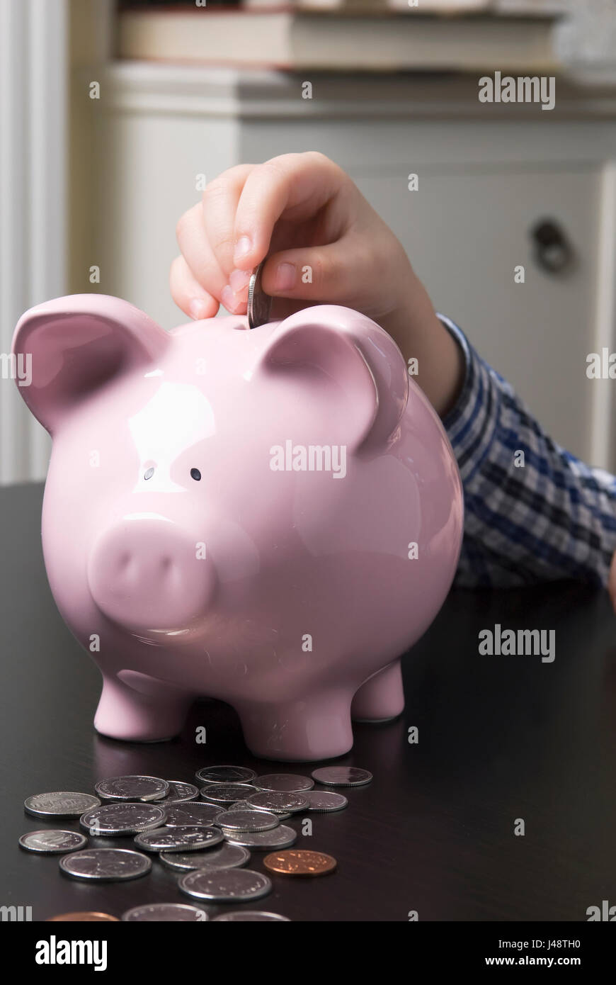 Child Depositing Coins Into A Piggy Bank; Laval, Quebec, Canada Stock ...