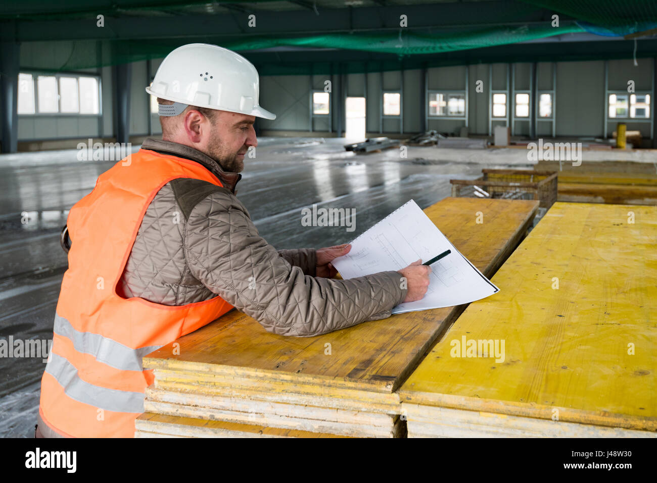 Construction supervisor with plan on site Stock Photo - Alamy