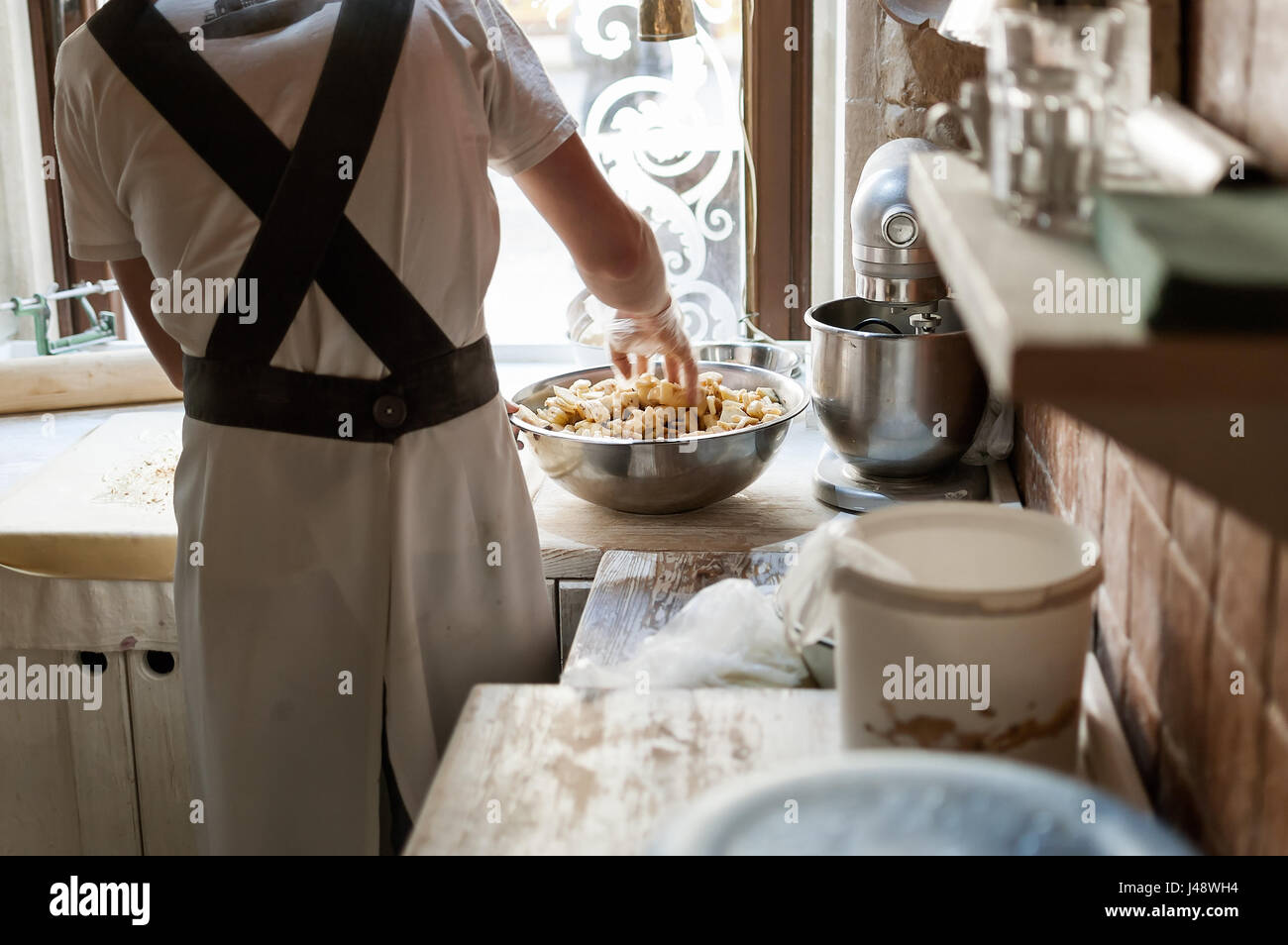 Baker is making a cake. Mixing fruits. Cooking process Stock Photo - Alamy