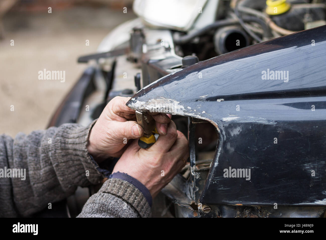 Repair service worker fix damaged car after crash on the road. Working ...