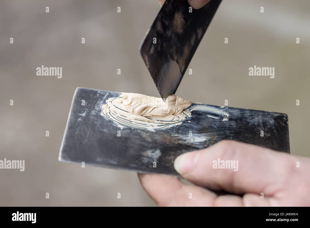 Worker mix hardener and filler material putty by metal spatula. Car ...