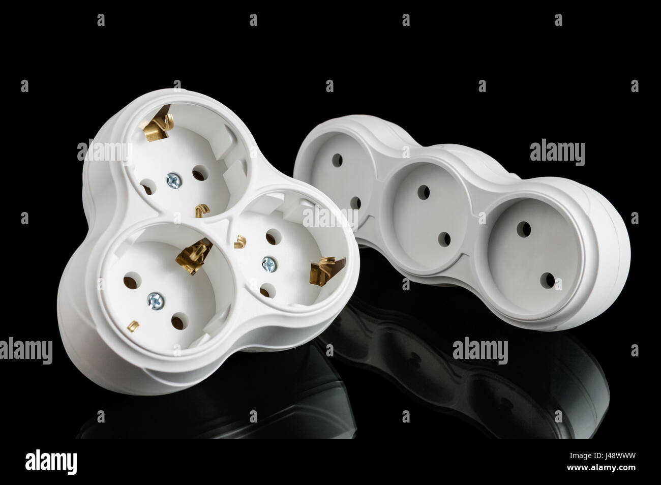Various triple electrical plug outlet on black background Stock Photo ...