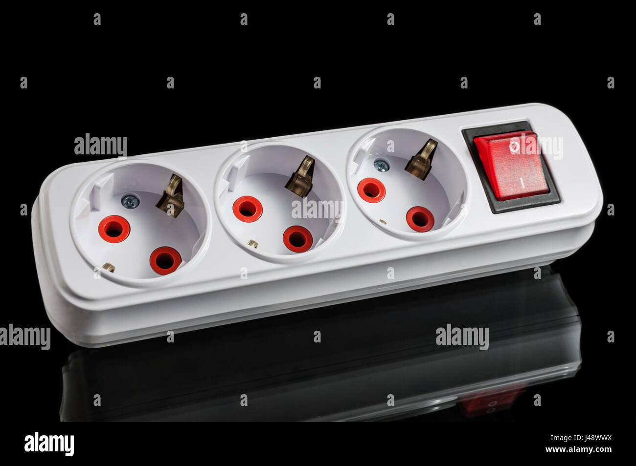 Triple electrical plug outlet on black background Stock Photo - Alamy