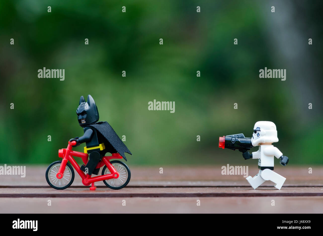 Lego batman riding bicycle chasing by stormtrooper Stock Photo - Alamy