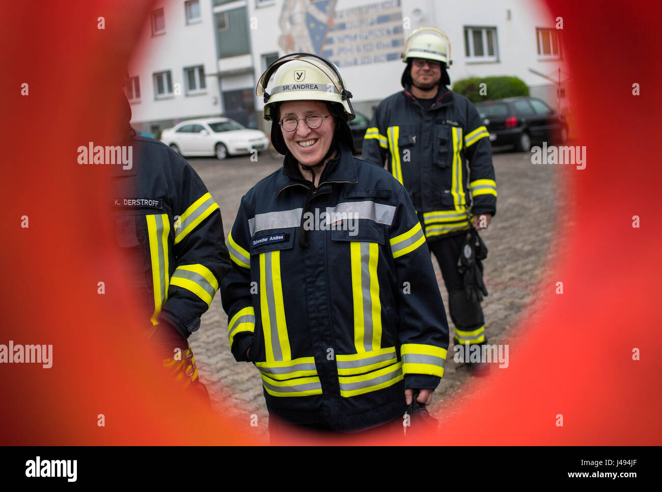 Sister Andrea Stadermann stands between her firefighter colleagues ...