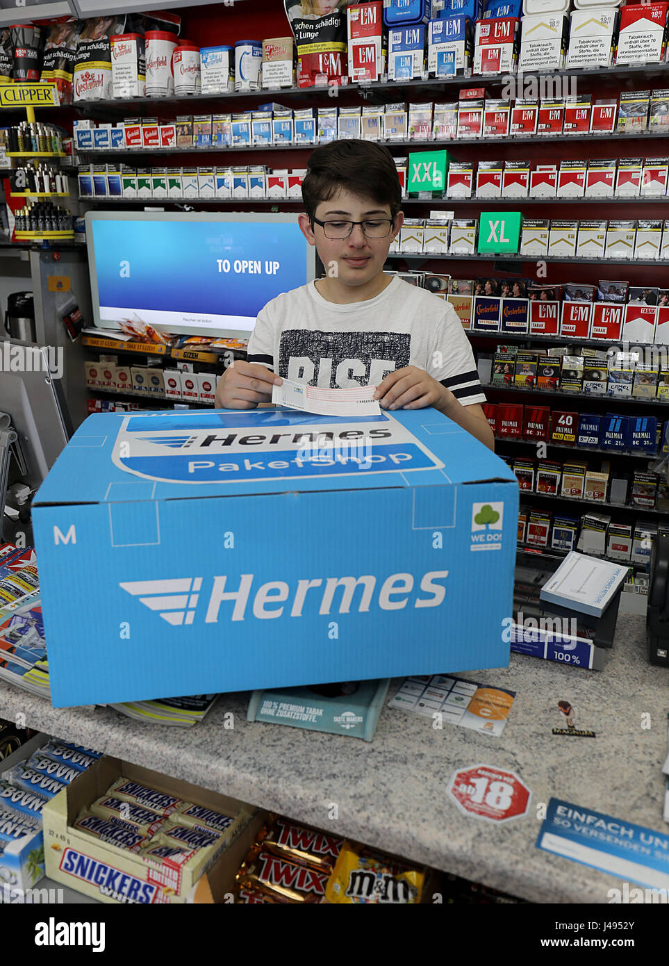 Cologne, Germany. 10th Mar, 2017. A young man handles a parcel at a ...