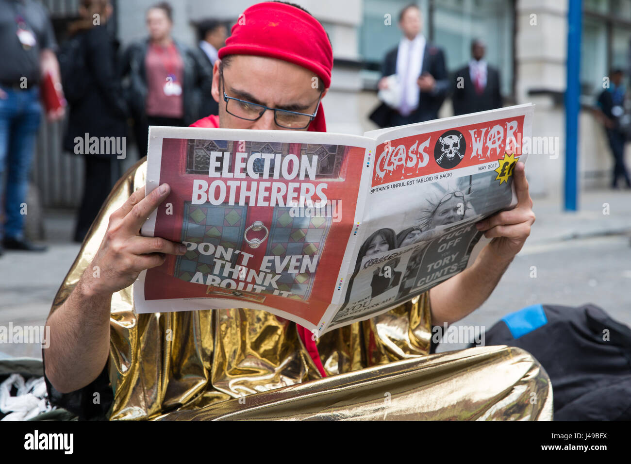 London, UK. 11th May, 2017. A Life Not Money activists reads 'Class War ...