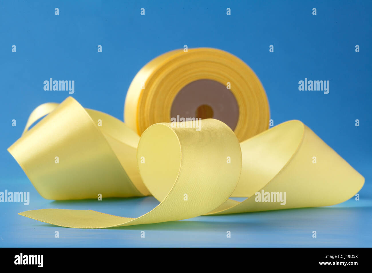 Yellow ribbon rolls Stock Photo - Alamy