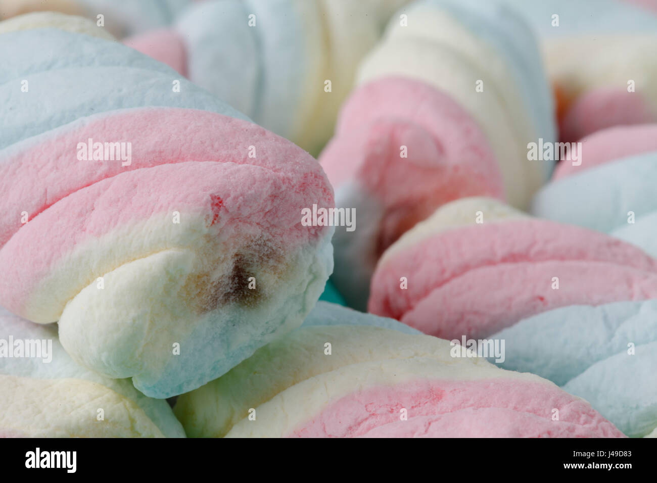 Rainbow color of spiral marshmallows on aquamarine and blue background ...