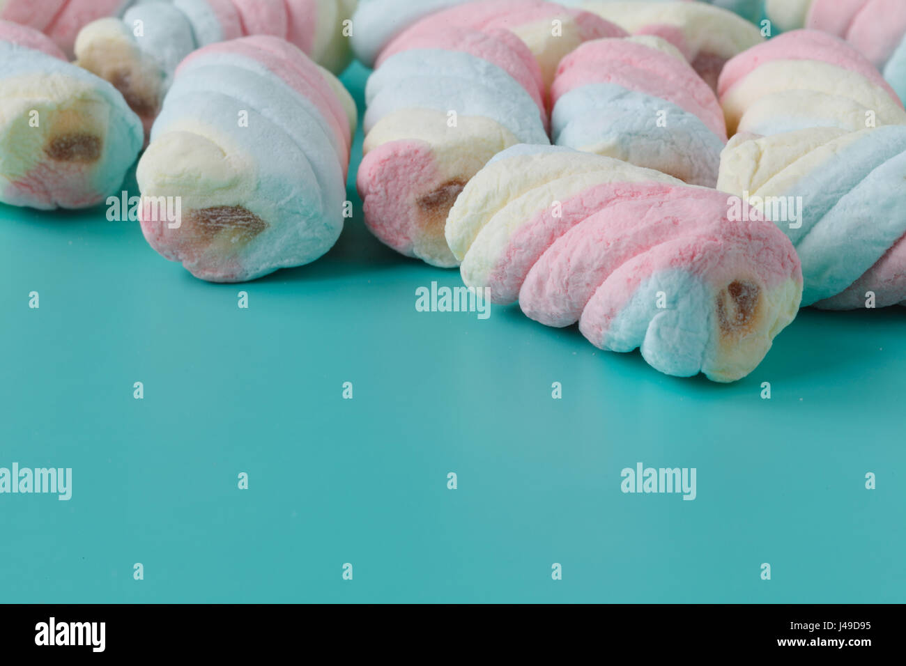 Rainbow color of spiral marshmallows on aquamarine and blue background ...