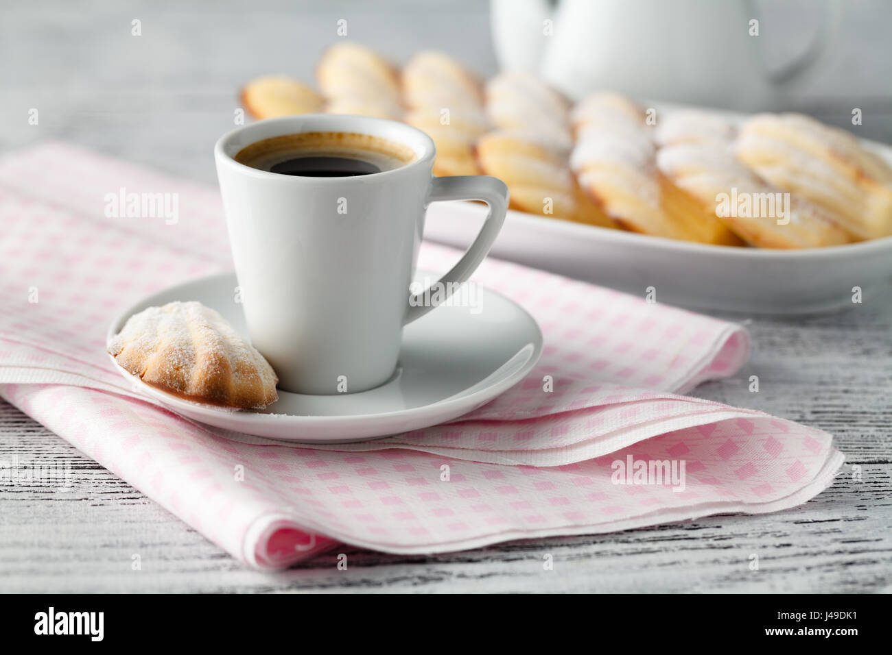 Icing lemon vanilla madeleine (shell-shaped cookies) on plate on the ...