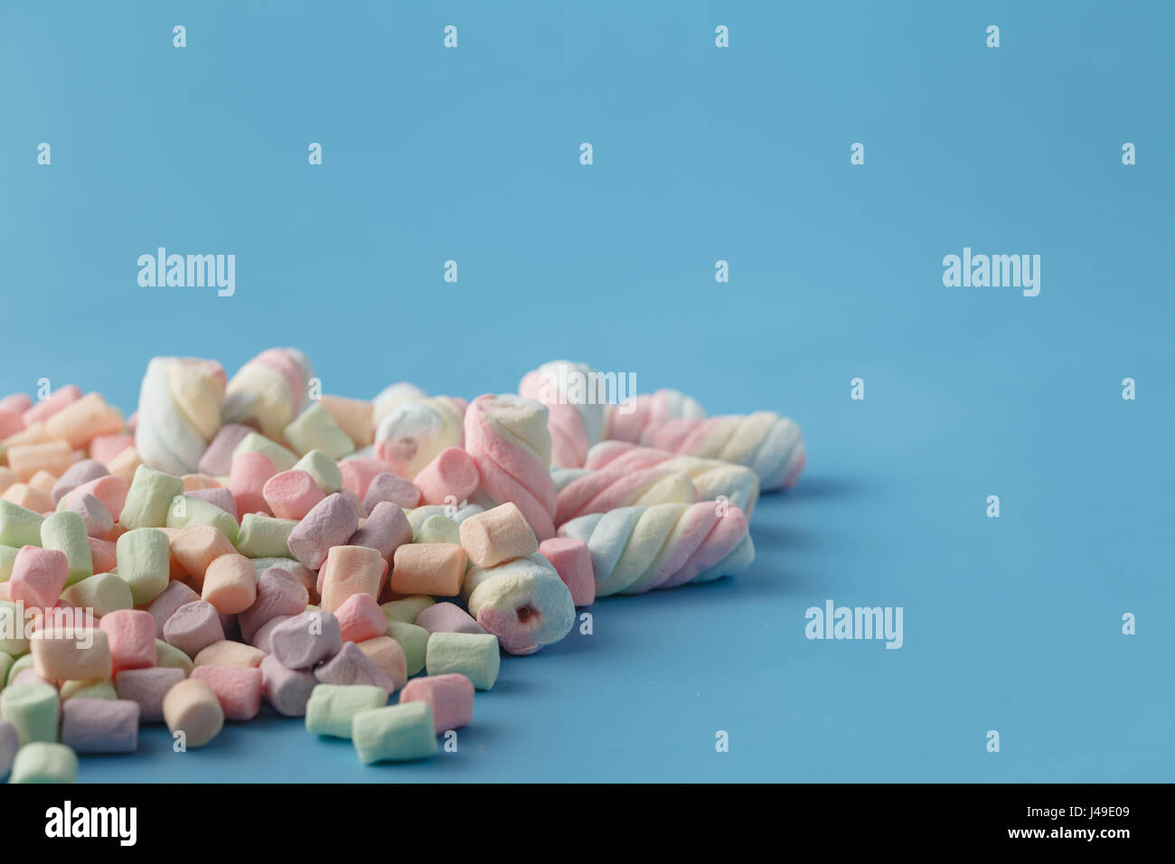 Twisted marshmallow on vibrant blue background Stock Photo - Alamy