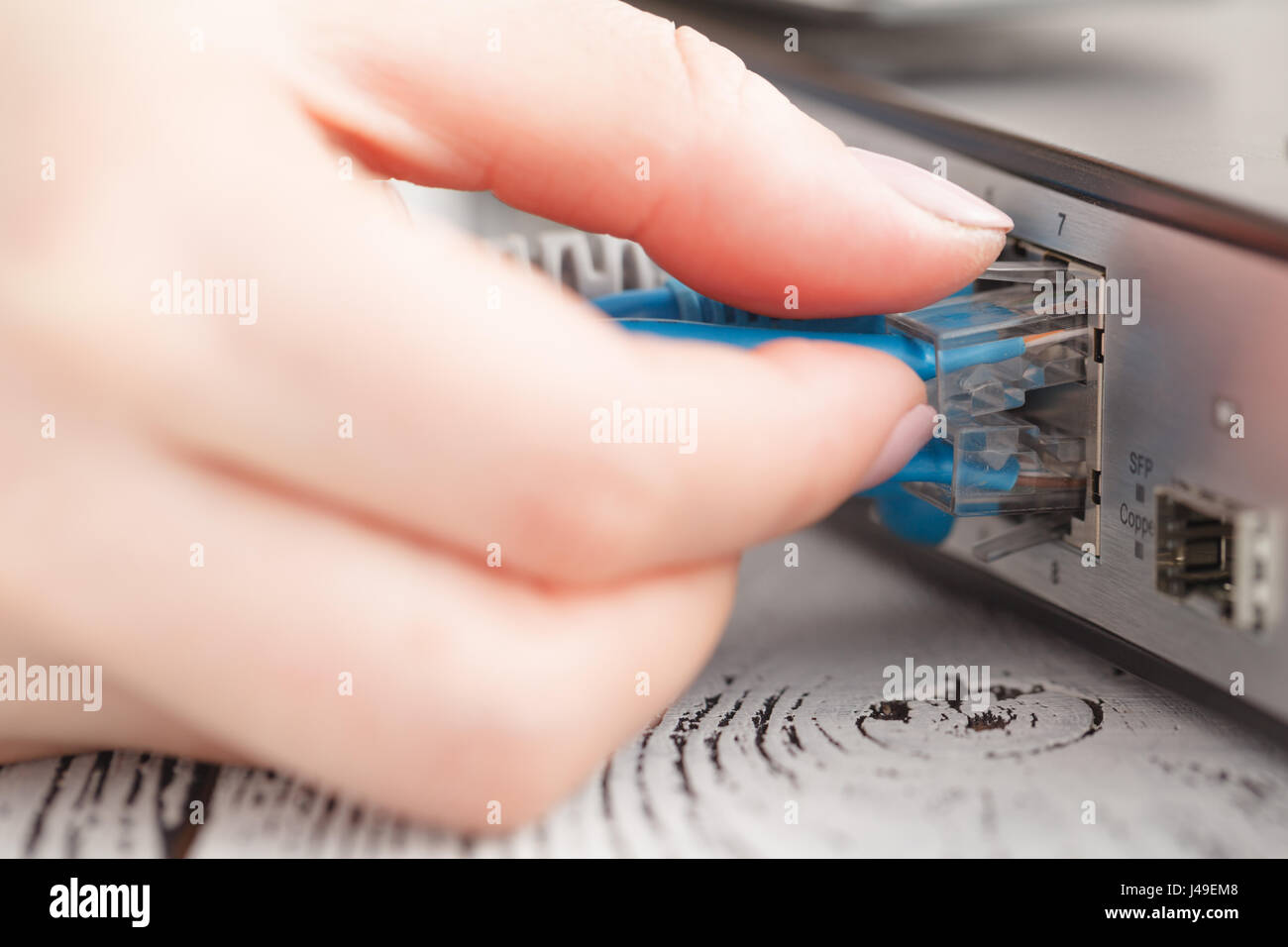 Insert network patch cord in lan commutator switch Stock Photo - Alamy