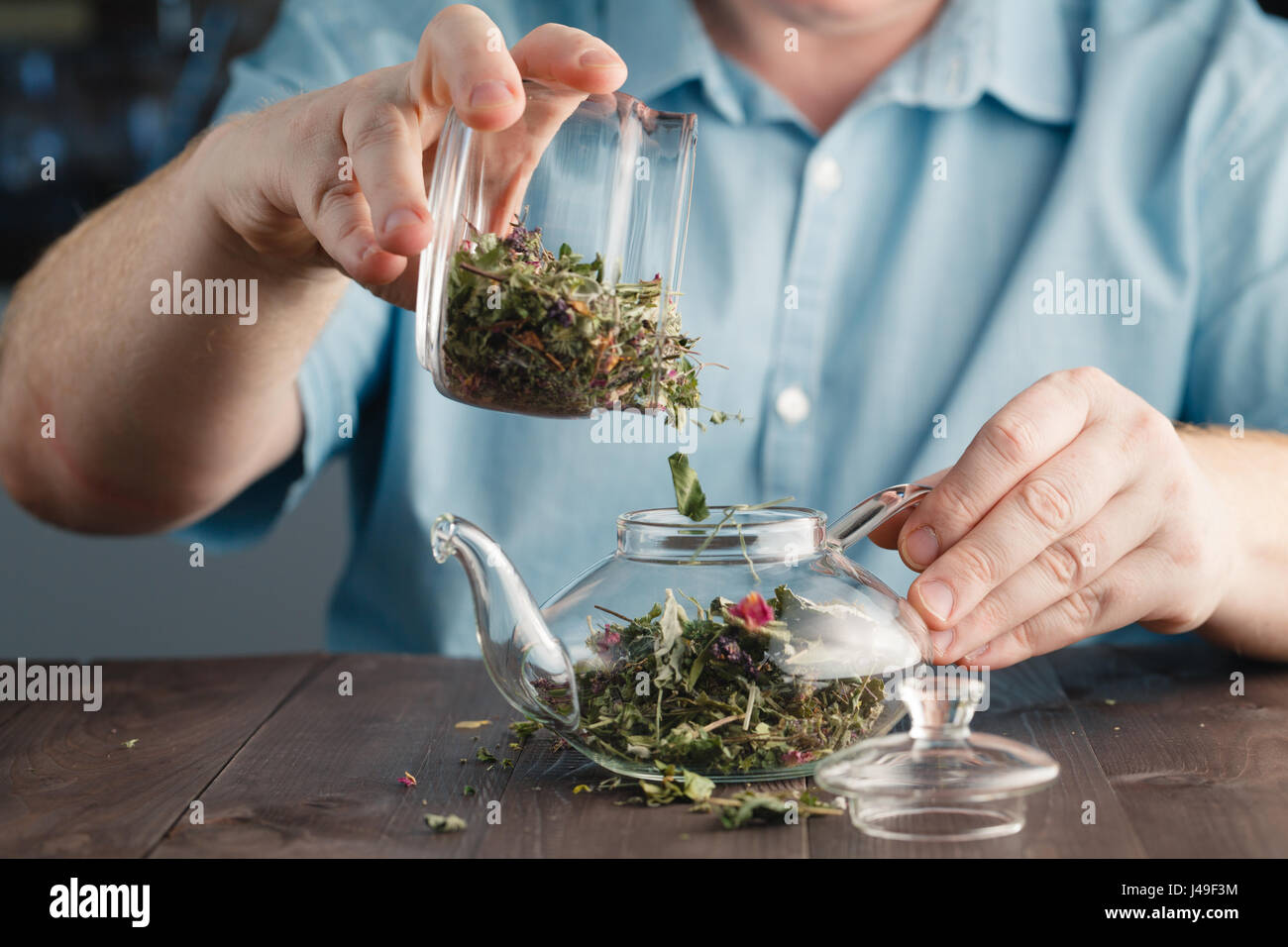 Male hands Puts herbal tea in the kettle Stock Photo - Alamy