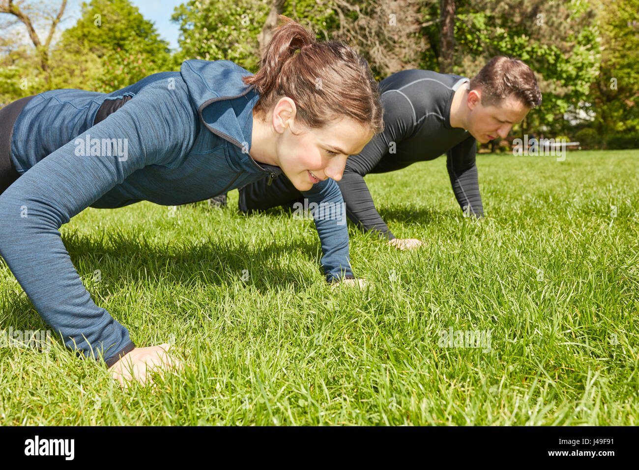 Couple making push ups in the park as fitness training Stock Photo - Alamy